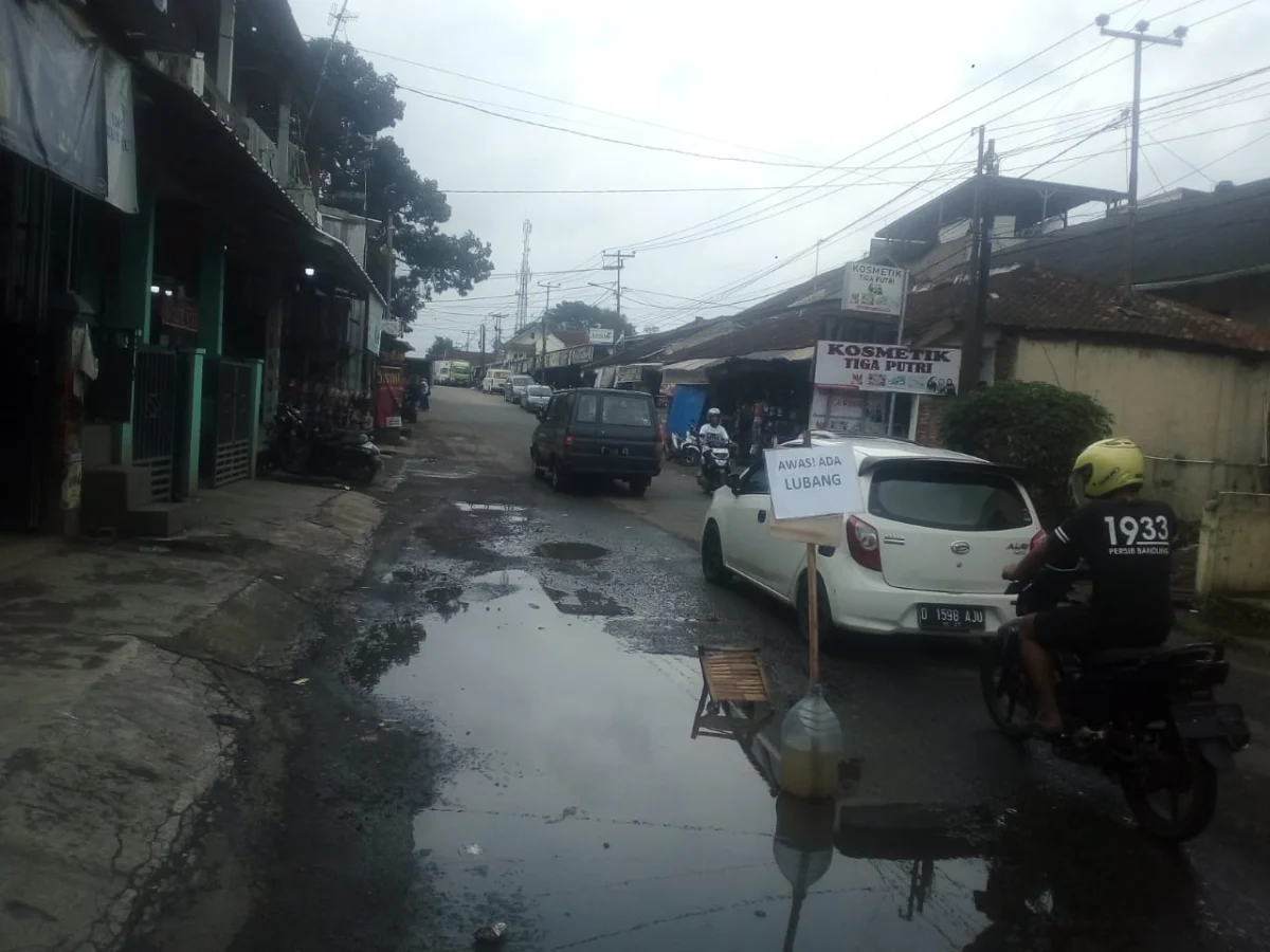 Warga Kampung Pasar Pasang Plang Pakai Galon Air di Jalan Berlubang ...